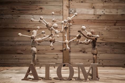 Premium Photo Close Up Of Wooden Figurines Holding Molecular Structure