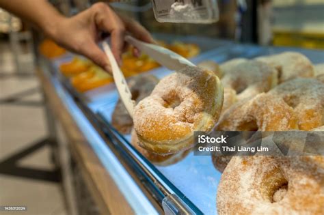 빵집 가게에서 도넛을 사는 여자가 쟁반과 서비스 집게를 들고 선택하는 경우 도넛에 대한 스톡 사진 및 기타 이미지 도넛 상점 가루 설탕 Istock