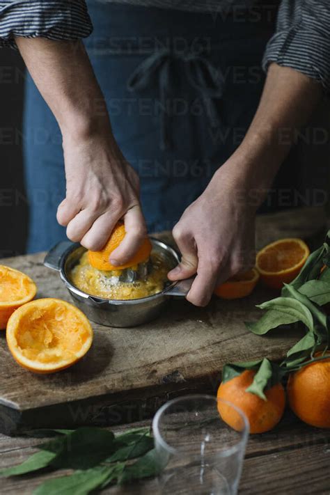 Young man's hands squeezing orange stock photo