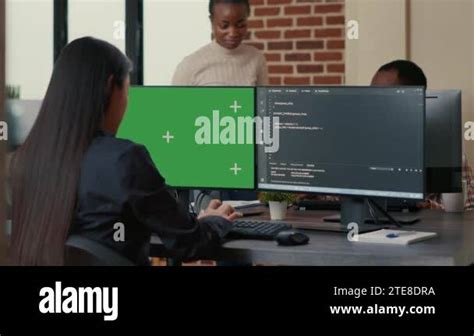 Software Developer Writing Algorithm In Front Of Computer With Green