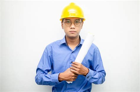 파란 셔츠와 노란 안전 헬멧을 쓴 아시아 건설 노동자가 심각한 표현으로 손을 교차시킵니다 개발에 대한 스톡 사진 및 기타 이미지 개발 건설 산업 건설 프레임 Istock