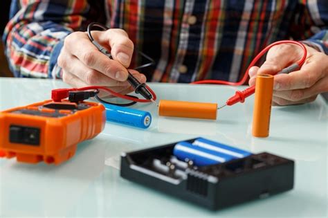 Premium Photo Electrician Measuring Battery Voltage With A Multimeter