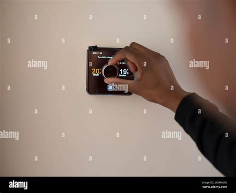Man Changing Temperature On Thermostat Stock Photo Alamy
