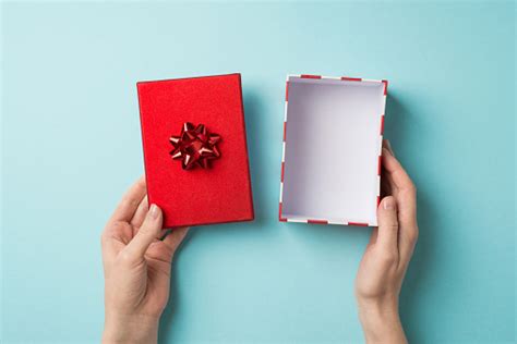 빈 공간이있는 고립 된 파스텔 블루 배경에 빨간색 뚜껑과 별 활이있는 열린 빈 선물 상자를 들고 있는 세인트 발렌타인 데이 장식의 1 인칭 탑 뷰 사진 선물 상자에 대한