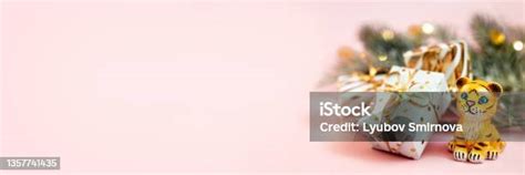 2022 년 중국 새해의 호랑이 상징 분홍색 파스텔 배경에 가지가 가문비 나무와 황금 선물 상자와 호랑이의 인형 공간을 복사합니다 기치 0명에 대한 스톡 사진 및 기타