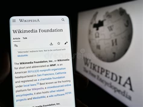 Person Holding Smartphone With Web Pag Eof Online Encyclopedia Wikipedia On Screen In Front Of