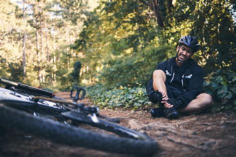 스포츠맨 부상 및 야외 자전거는 다리 통증과 함께 자연에서 산악 자전거를 타면서 자전거를 타고있다 운동 선수는 피트니스 운동 훈련 또는 운동을 위해 숲에서 충돌 또는 추락