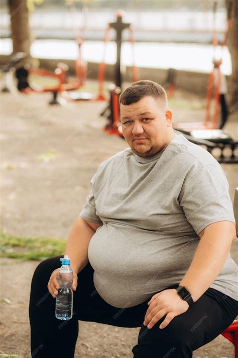 Premium Photo Very Fat Guy Drinks Water After Training In The Park In