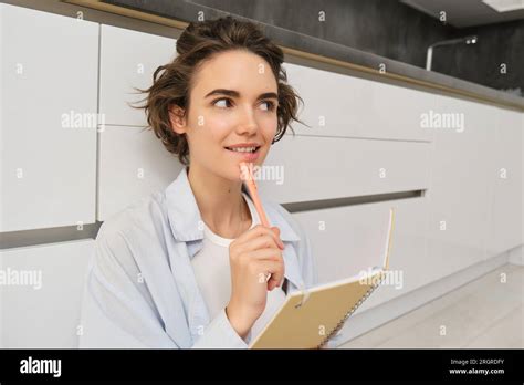 Portrait Of Beautiful Young Woman Writing In Journal Adding Notes In