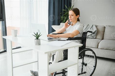 Female Freelance Programmer Sitting In Wheelchair And Using Computers