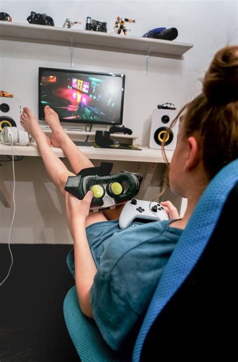 White Game Controller In The Hands Of A Teenage Girl With Headphones