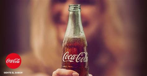 A Woman Holding Up A Coca Cola Bottle With The Caption S Name On It