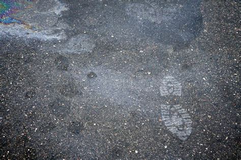 Close Up Of A Footprint And Gasoline Spill Forming An Abstract Pattern