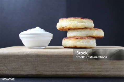 화이트 사워 크림 소스를 곁들인 나무 트레이에 아침 식사 코티지 치즈 팬케이크 치즈케이크 러시아식 아침 식사 요리 코티지 치즈 건강 식품 0명에 대한 스톡 사진 및 기타