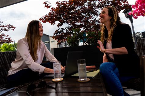 꽃이 만발한 자연의 아름다움 속에서 분홍색 꽃으로 뒤덮인 퍼걸러 아래 야외 카페에 두 명의 여성이 모인다 20 24세에 대한 스톡 사진 및 기타 이미지 Istock