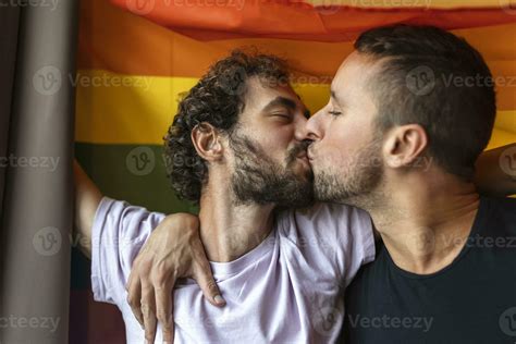 Passionate Gay Couple Making Out With Lgbtq Flag In The Background