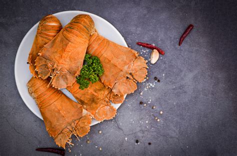 해산물 레스토랑에서 파슬리 로즈마리와 신선한 슬리퍼 랍스터 플랫 헤드 삶은 요리 흰색 접시와 해산물 소스에 제공되는 플랫 헤드 랍스터 새우 록 랍스터 모튼 베이 버그 0명에