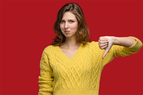 빨간 배경에 스튜디오에서 노란색 점퍼를 입은 젊은 여성 싫어하는 제스처가있는 컨셉 사진 감정에 대한 스톡 사진 및 기타 이미지