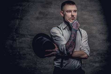 흰 셔츠와 멜 빵 입고 젊은 구식 문신된 남자의 초상화는 실린더 모자를 보유 하고있다 어두운 배경에 고립 갈색 머리에 대한 스톡 사진 및 기타 이미지 Istock