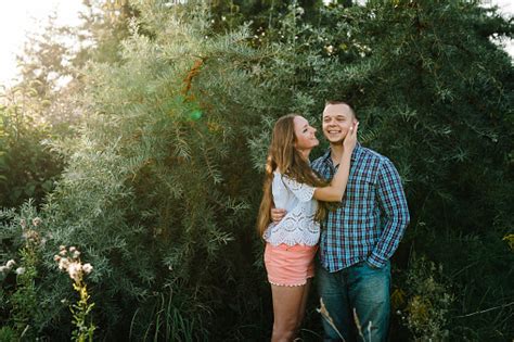 젊은 부부는 잔디에 서서 가을에 야외에서 일몰에 포옹 태양의 배경에 필드에 남자와 여자 사랑과 가족의 개념 전체 길이 2명에 대한 스톡 사진 및 기타 이미지 Istock