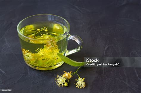 차 한 잔린든 꽃 차 검은 테이블에 린든 신선한 꽃뜨거운 허브 차 한 잔 건강한 라이프스타일녹색 잎이 있는 차 한 잔은 검은색 배경핫 드링크카피 공간 0명에 대한 스톡 사진