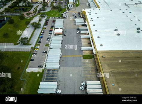 Aerial View Of Large Commercial Loading Bay With Many Delivery Trucks Unloading And Uploading