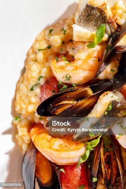 해산물과 로즈 와인 한 잔을 곁들인 프레골라 파스타 음식은 흰색의 세라믹 접시에 놓여 있고 칼은 근처에 있습니다 파스타 한 접시가 하얀 식탁보 위에 놓여 있다 0명에 대한