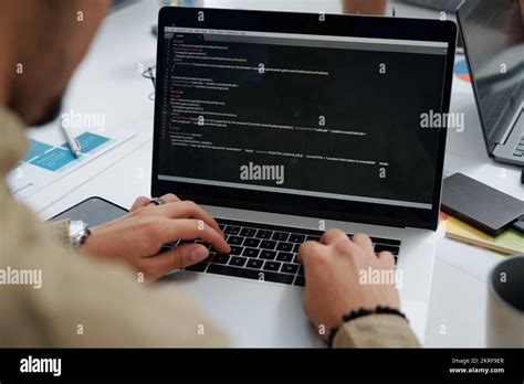 Close Up Of Young Developer Writing Codes On Computer While Working At