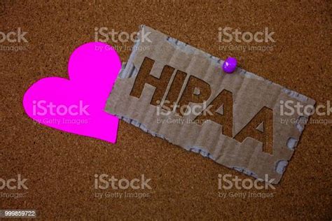 개념적 손을 보여주는 Hipaa 쓰기입니다 비즈니스 사진 텍스트 건강 보험 이동성 및 책임 법 의료 법 브라운 오래 된 손상 된 판지 아이디어 핑크 하트 코르크 배경