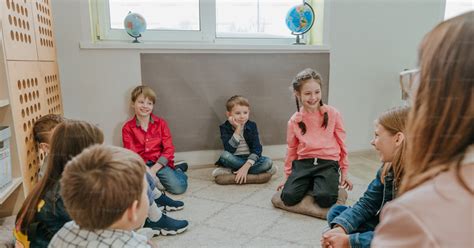 캐주얼 한 옷을 입은 초등학생들이 바닥에 앉아 교실에서 이야기하고 있습니다 학교 개념으로 돌아갑니다 선택적 초점 사진 Unsplash의 마루 이미지