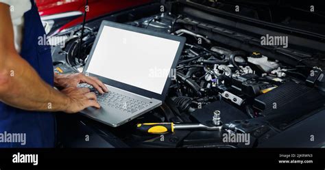 engine diagnostics - car mechanic using laptop computer to diagnose vehicle motor in repair shop ...