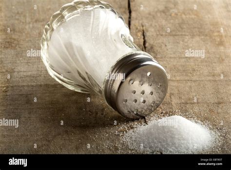 Traditional Glass Salt Cellar And Spilled Salt On A Wood Background