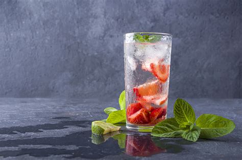 얼음 조각모히토 칵테일 여름 레모네이드 또는 아이스 티 한 잔 어두운 배경에 딸기 라임 민트와 상쾌한 시원한 해독 음료 건강한 식생활 텍스트용 오피 공간 0명에 대한 스톡