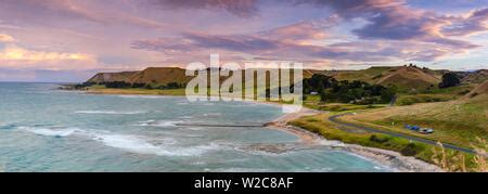 New Zealand Mahia Beach Ocean Sunset With Cliff In Background Stock