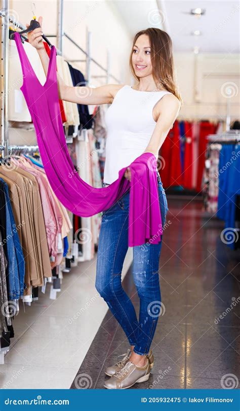 Jovencita Sonriente Tratando De Un Nuevo Vestido Imagen De Archivo Imagen De Minorista