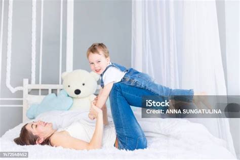 행복하고 사랑이 넘치는 가족 엄마와 아기 아들은 침대에서 집에서 놀고 재미 있고 웃는다 2 3 살에 대한 스톡 사진 및 기타