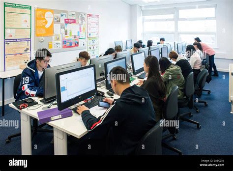 A Computer Technology Class With Students Working And Helping Each