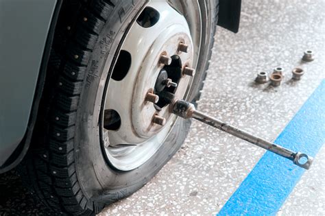 차고에 있는 자동차의 펑크난 타이어의 타이어 피팅 자동차 서비스에서 펑크 난 타이어 교체 바퀴의 클로즈업 사진입니다 타이어에 대한 스톡 사진 및 기타 이미지 Istock