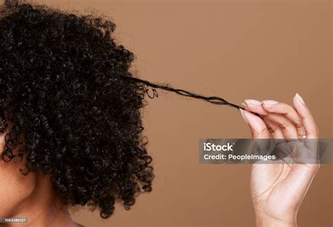 헤어 케어 뷰티 스튜디오에서 갈색 배경에 곱슬머리를 한 흑인 여성 손 미용실 웰빙 및 성장 자연스럽고 건강한 모발을 위한 컬