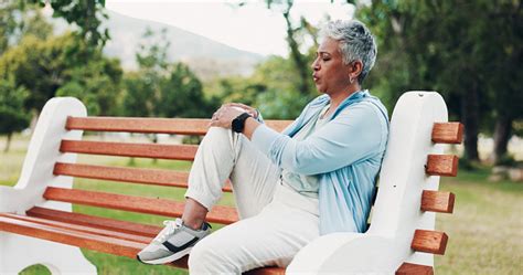 무릎 통증 피트니스 및 부상 근육 긴장 및 벤치에 염증이 있는 공원의 성숙한 여성 자연 스포츠 그리고 사고가 있는 고령자 운동