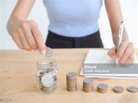 항아리에 동전과 2021 년 동안 돈을 절약 할 계획을 작성 하는 슬림 하 고 피부 황갈색 여자의 흐림 이미지와 나무에 현금을 스택 미래의 금융 개념 개념에 대한 스톡 사진