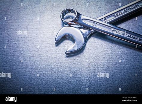 Flat Spanner And Hook Spanner On A Metallic Background Design Concept