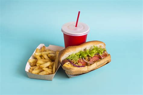 패스트 푸드 개념 소시지가있는 신선한 핫도그 프렌치 프라이 및 파란색 배경에 튜브가있는 종이 컵 프렌치 프라이에 대한 스톡 사진 및 기타 이미지 Istock