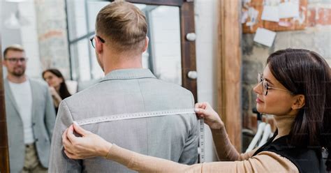 자신의 작업장에서 고객 어깨의 너비를 측정하는 여성 재단사의 후면보기 사진 Unsplash의 몸짓 이미지