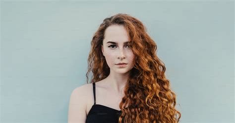 파란색 바탕에 빨간 곱슬머리를 가진 생강 여자의 초상화 사진 Unsplash의 초상 이미지