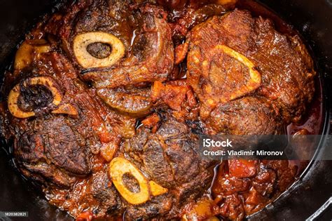 Osso Buco 크로스 컷 송아지 정강이 토마토와 향신료로 찐 쇠고기 고기 Ossobuco 흰색 배경입니다 상위 뷰 갈색에