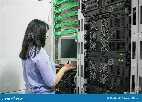 A Female Programmer Is Working In A Server Room The Girl Is Standing