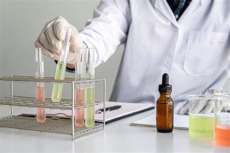 Scientist Or Medical In Lab Testing Sample Trial With Reagent Mixing Reagents In Glass Flask