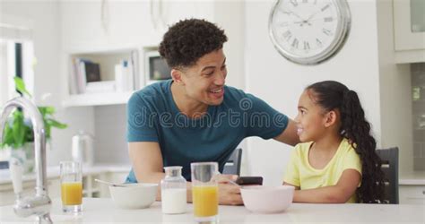 Happy Biracial Father and Daughter Eating Breakfast and Using Smartphone Together Stock Footage ...