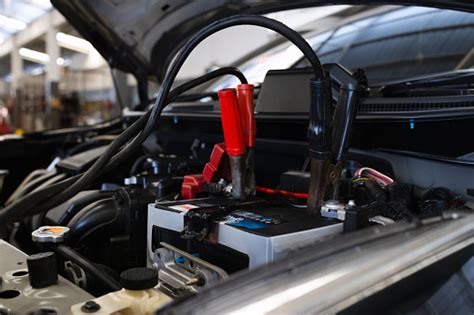 자동차 수리 개념 부드러운 초점과 백그라운드에서 빛을 통해 점퍼 케이블을 통해 전기와 자동차 배터리를 충전 클로즈업 교통수단에